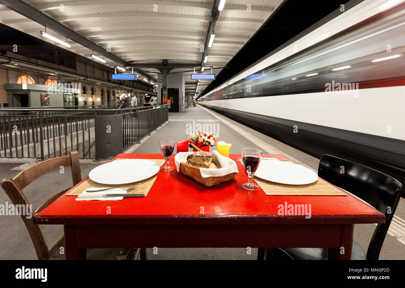 laid table for two persons on the sidewalk of a train station, outdoors ...