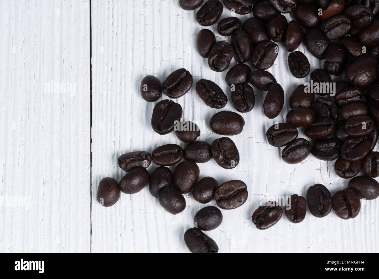 Roasted coffee beans on white wood table. coffee background with copy ...