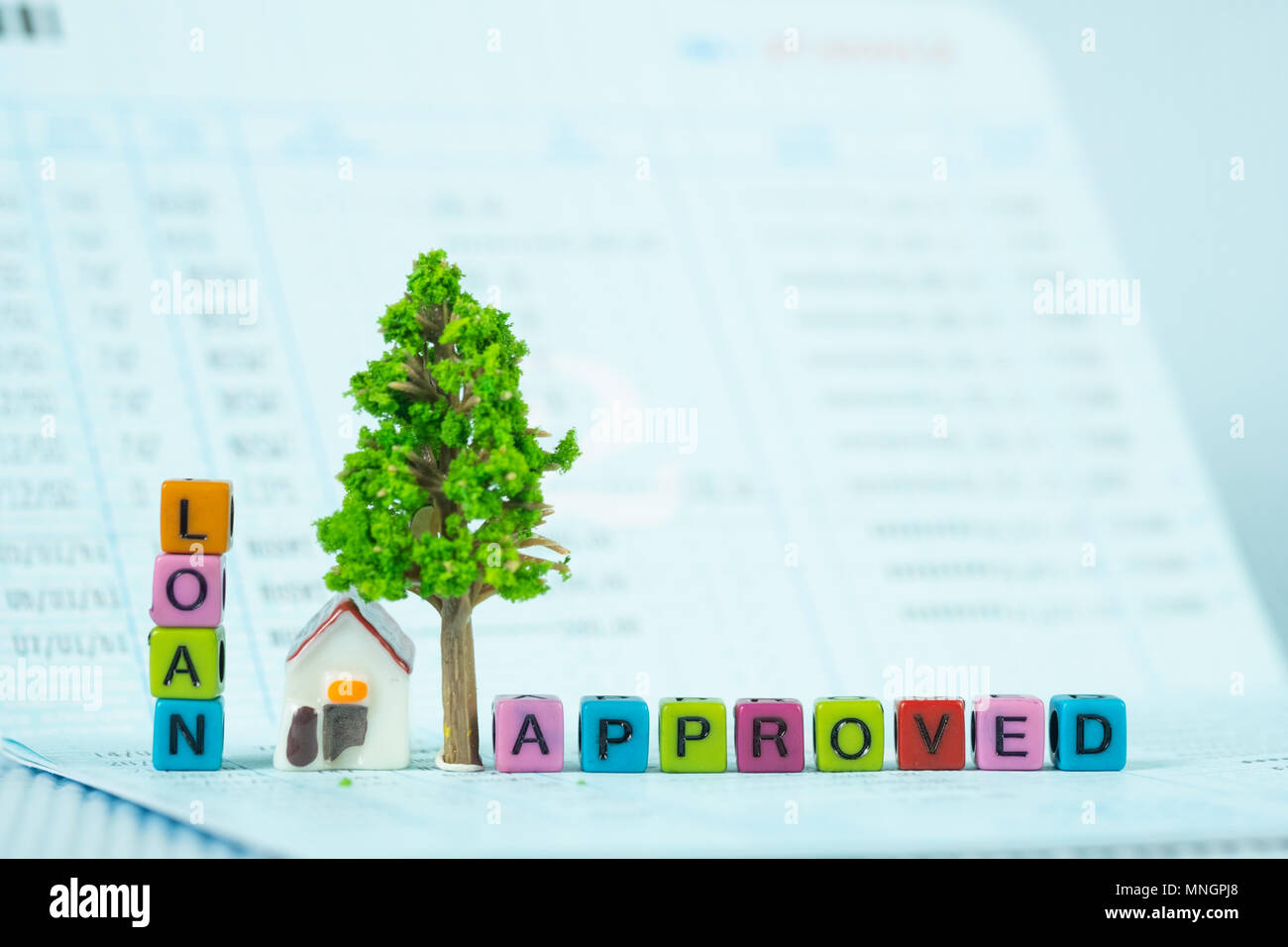 LOAN text and small model house and little tree with notebook, savings ...