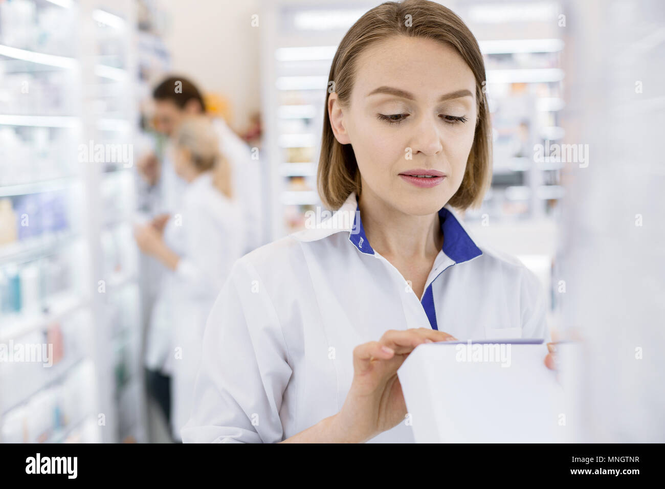 Meditative female pharmacist studying medication Stock Photo - Alamy