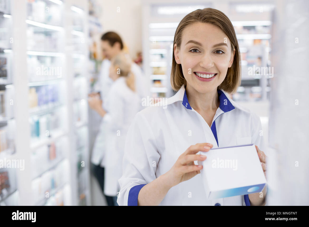 Joyful female pharmacist taking drug Stock Photo - Alamy