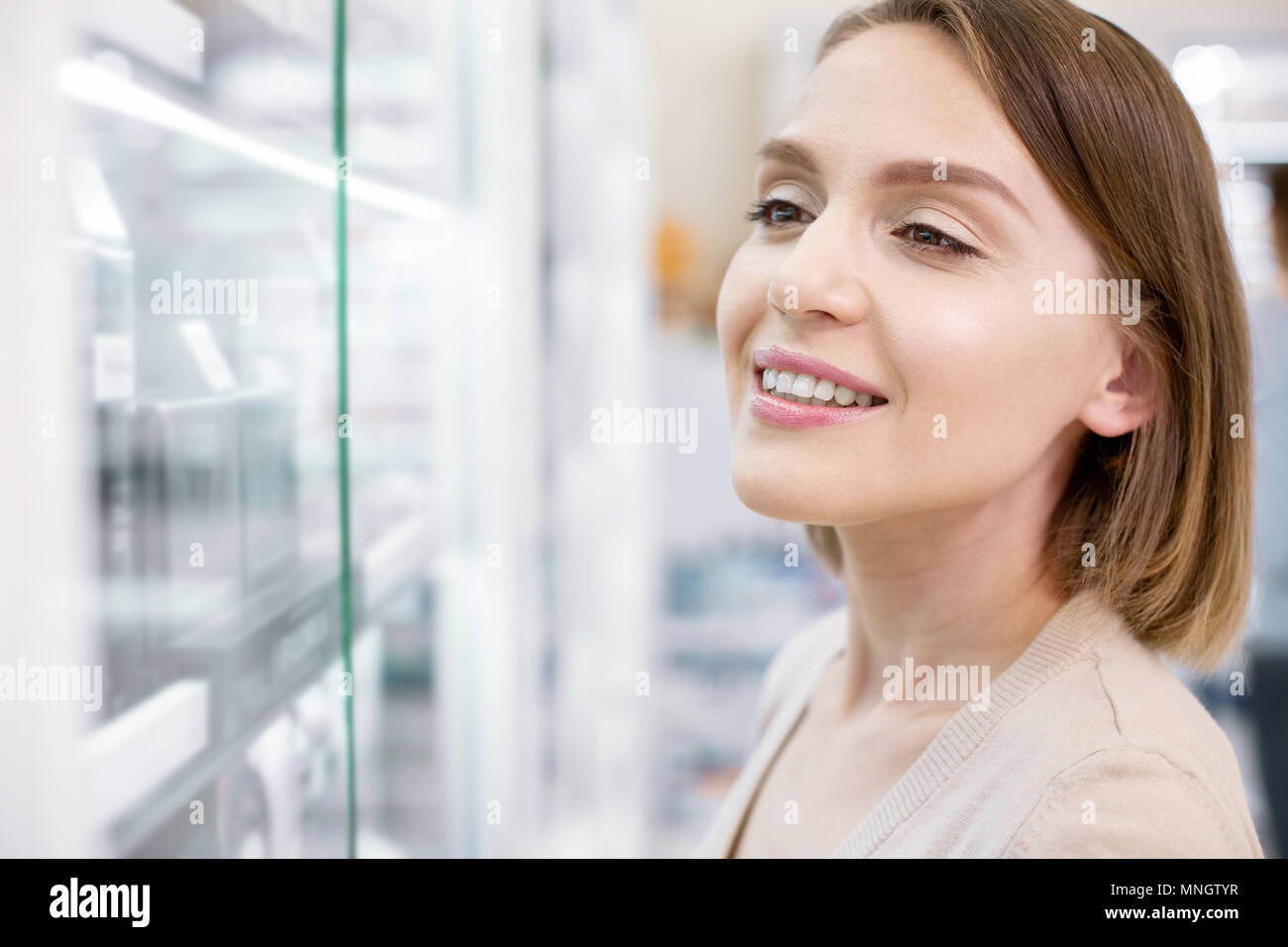 Positive jolly woman trying to find product Stock Photo - Alamy