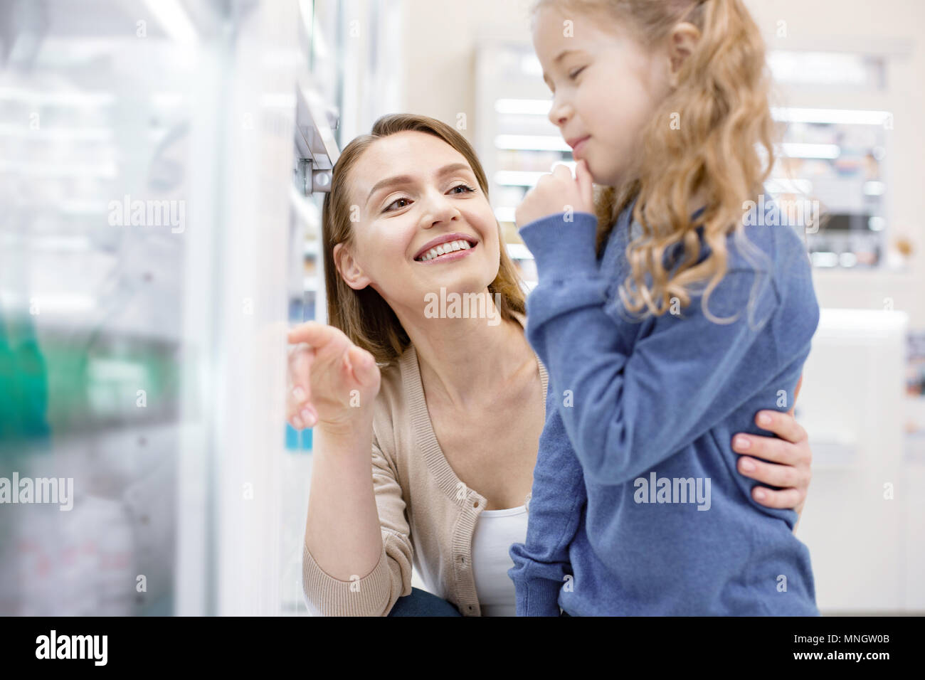 Cheerful merry woman giving explanation to girl Stock Photo - Alamy