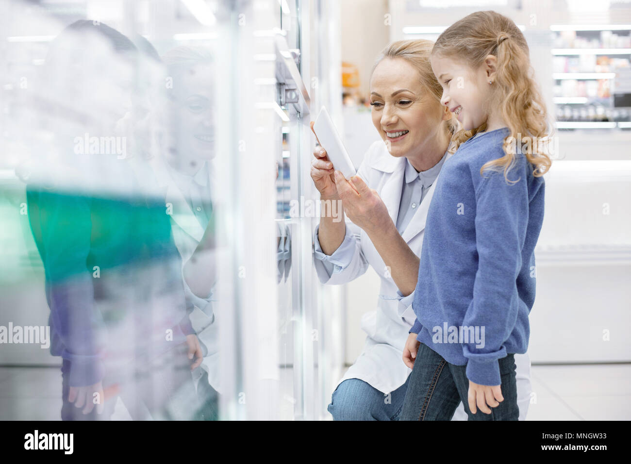 Nice female pharmacist educating girl Stock Photo - Alamy