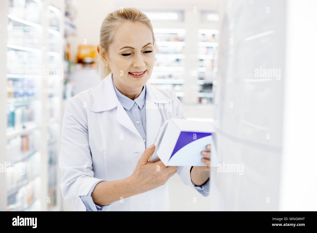 Pretty female pharmacist identifying pills Stock Photo - Alamy