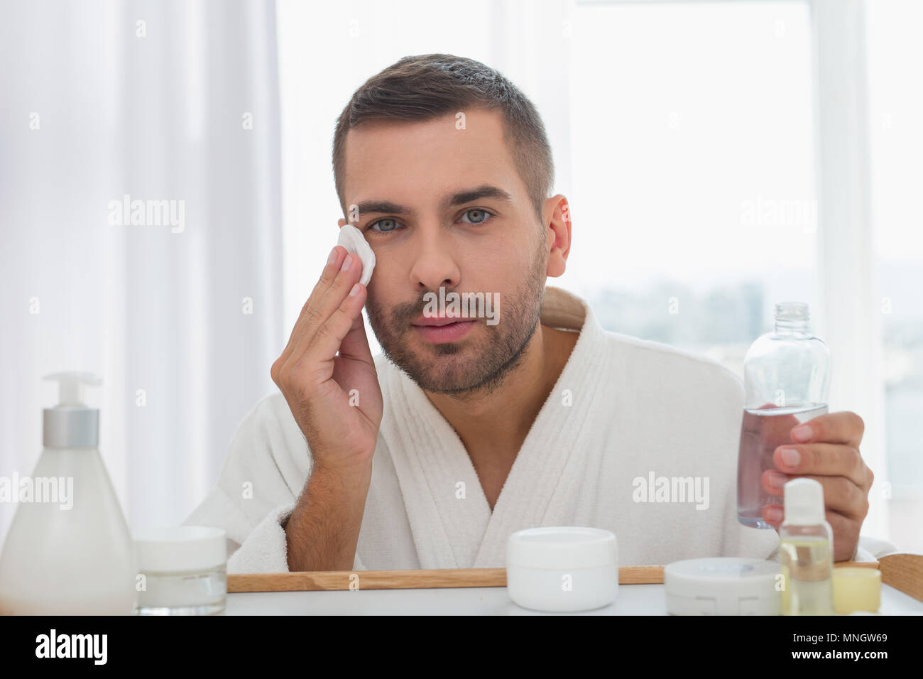 Nice serious man cleaning his skin Stock Photo - Alamy