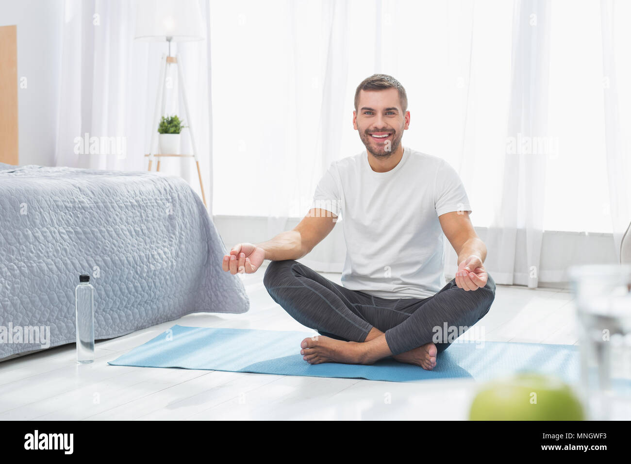 Nice cheerful man meditating Stock Photo - Alamy