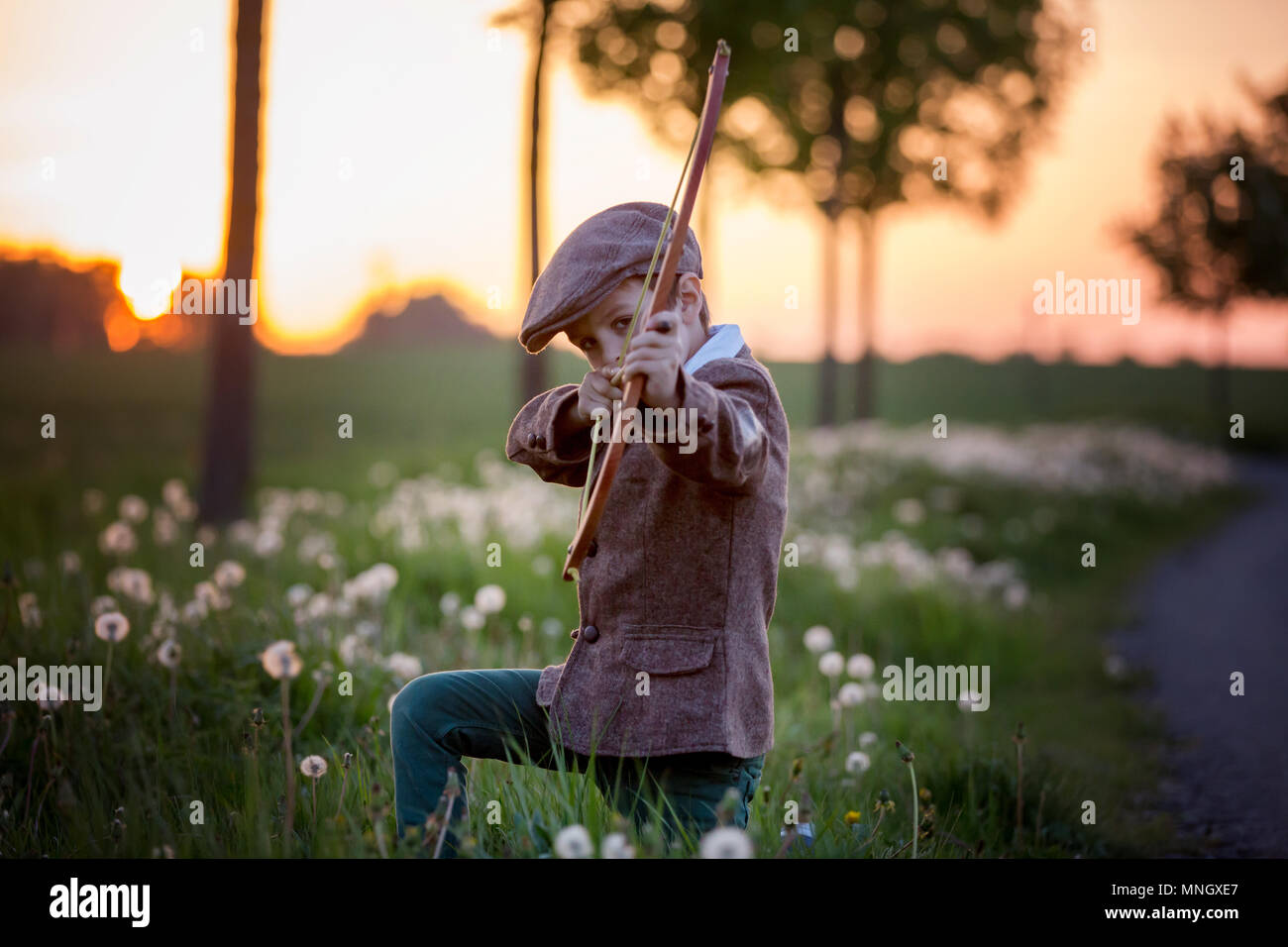 Portrait of child playing with bow and arrows, archery shoots a bow at ...