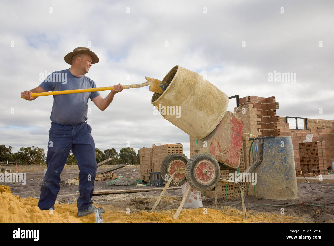 Man shoveling cement hi-res stock photography and images - Alamy