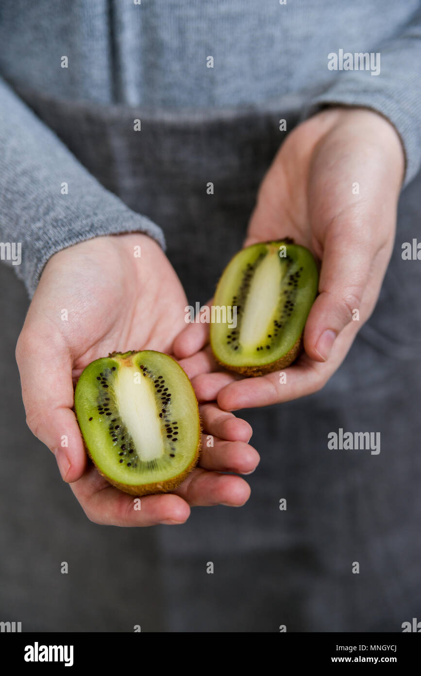 Close up female hands holding fresh sliced kiwi fruit Stock Photo - Alamy