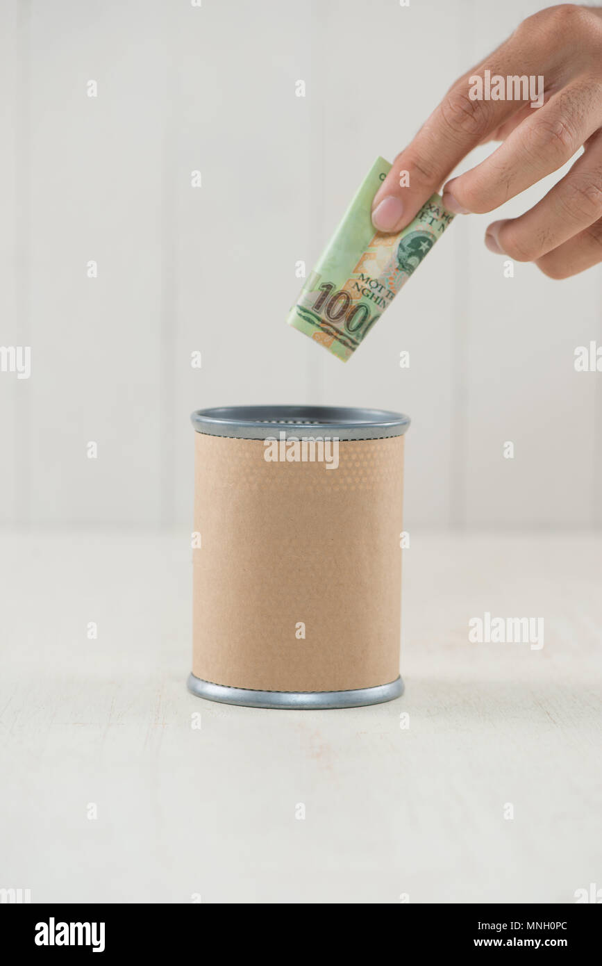 Putting money into donation box. Donate concept Stock Photo - Alamy