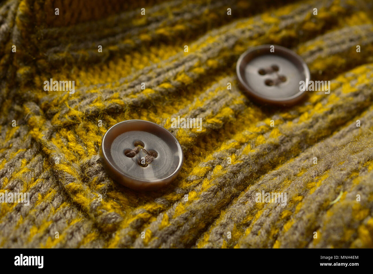 sewing buttons attached to the wool sweater - closeup Stock Photo - Alamy
