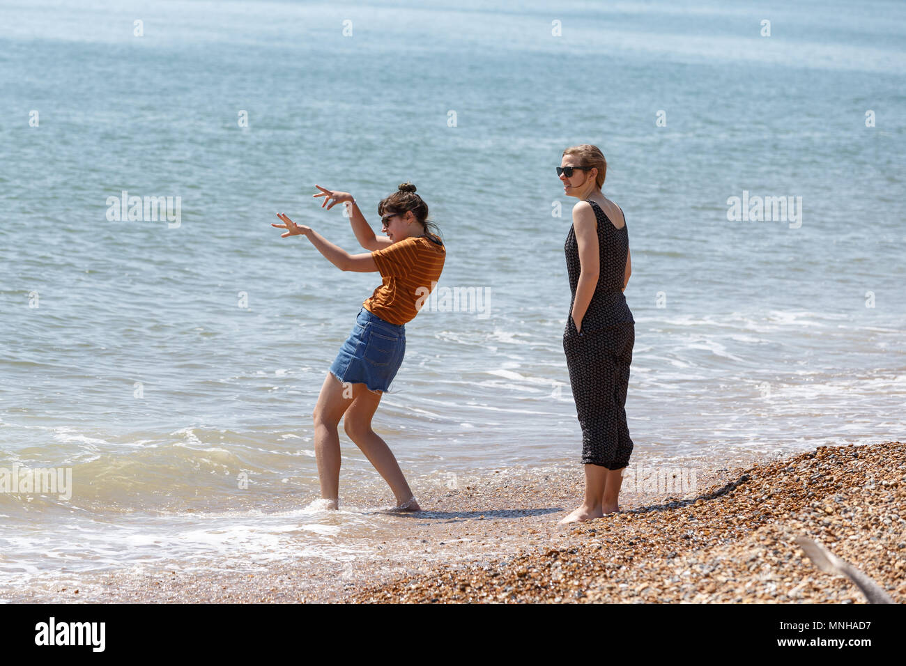 Two girls playing around in the sea on a hot day. / Late teen girls, UK ...