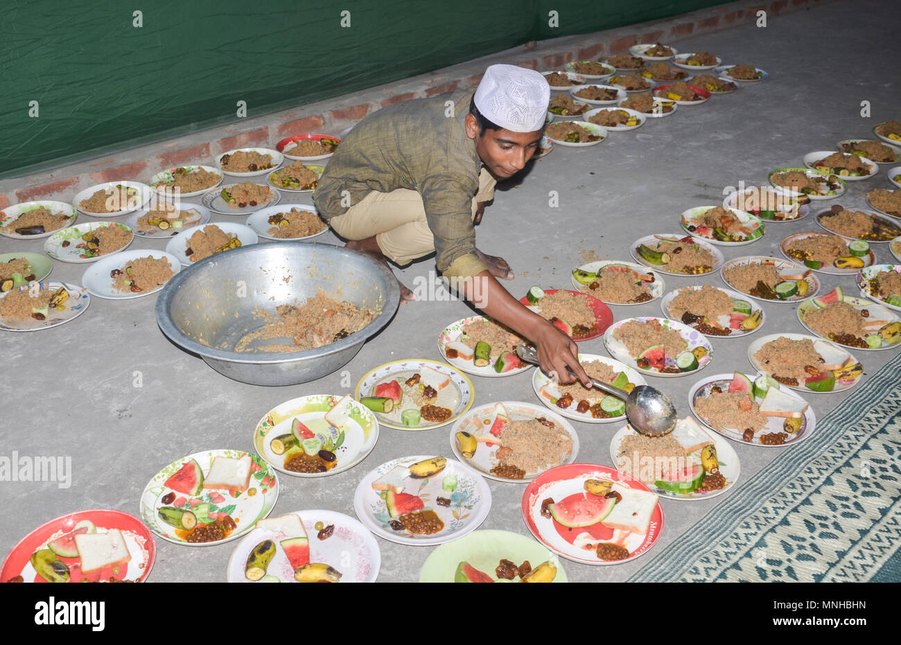 Guwahati, India. 17th May, 2018. A Muslim boy prepares the plates for ...