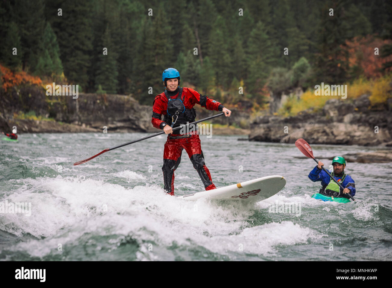 Two adventurous men paddleboarding and kayaking down snake river hi-res ...