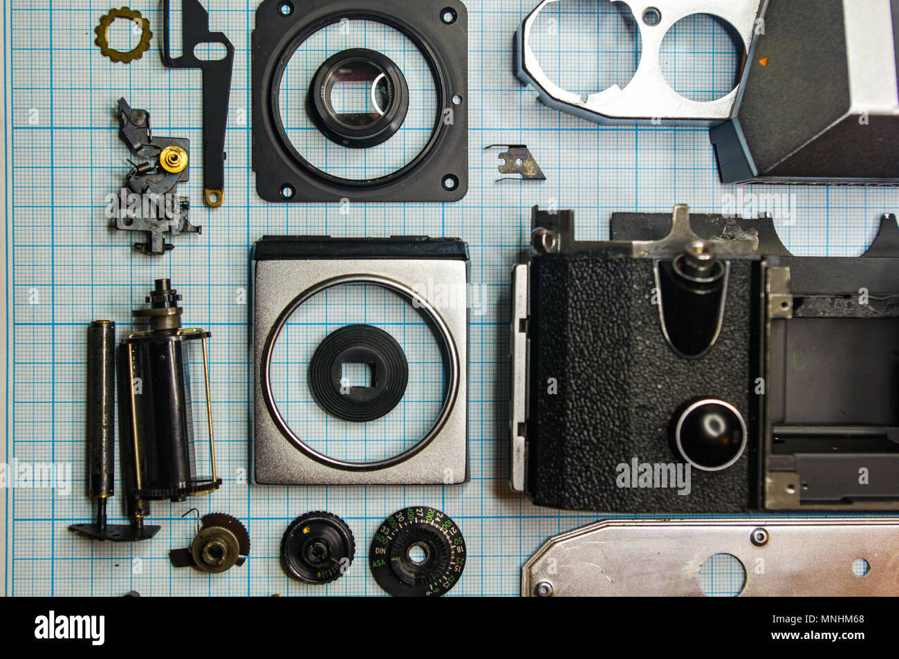 parts are completely disassembled old retro film SLR camera on graph ...
