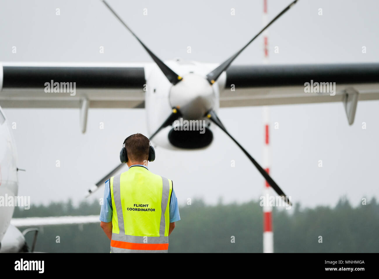 A flight coordinator is watching an airplane as it prepares for take ...