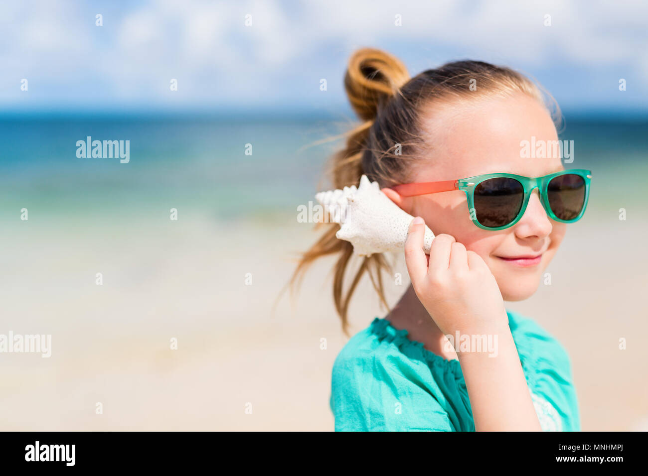 Little girl with seashell hi-res stock photography and images - Alamy