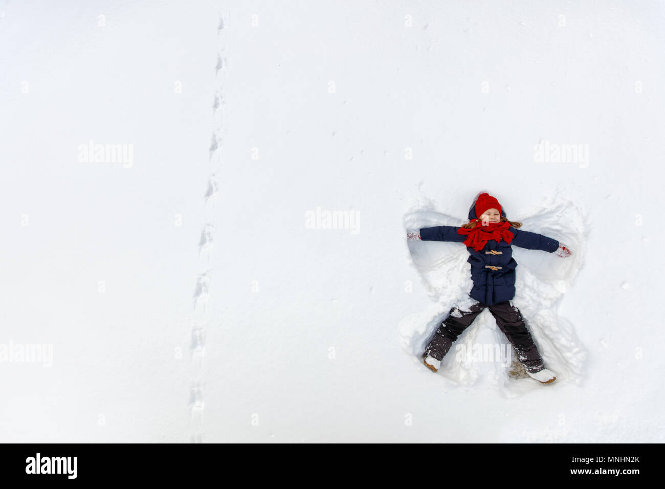 Above view of adorable little girl enjoying beautiful winter day making ...