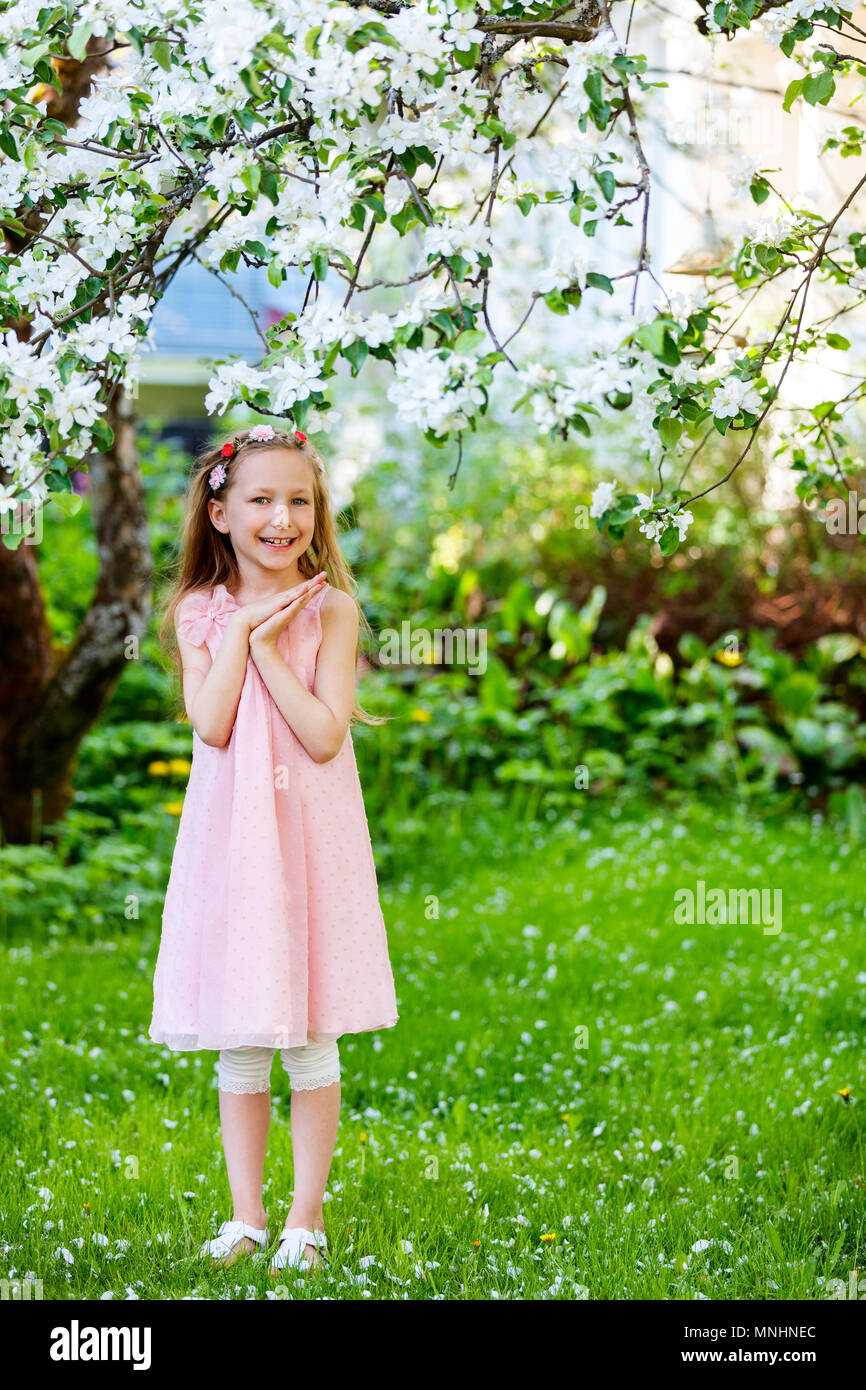 Adorable little girl in in blooming apple tree garden on spring day Stock Photo - Alamy