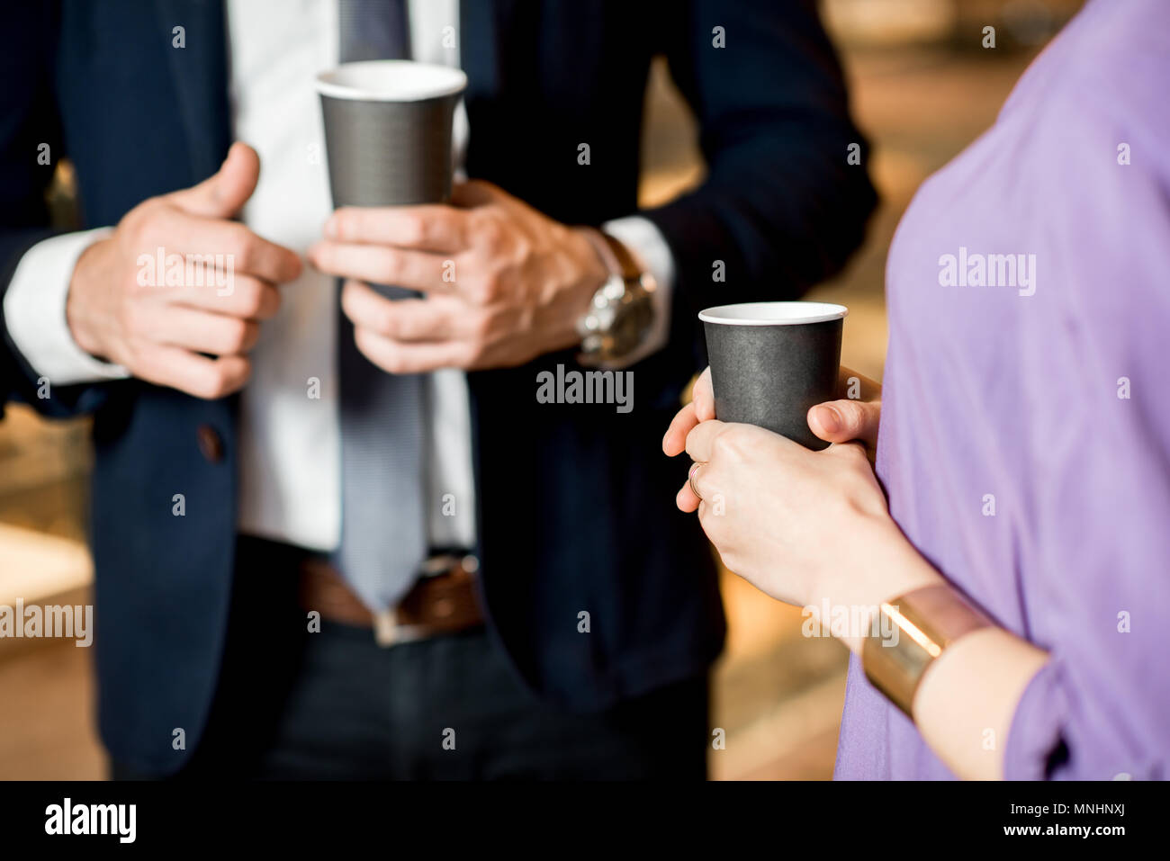 Business people with coffee cups indoors, close-up view with no face ...