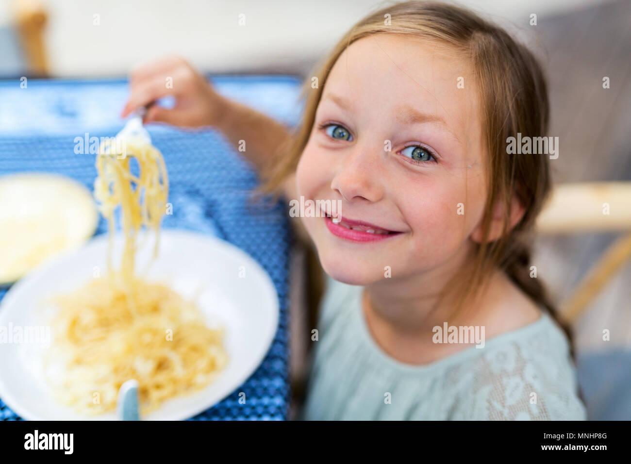 Portrait of adorable little girl eating spaghetti for a lunch at ...