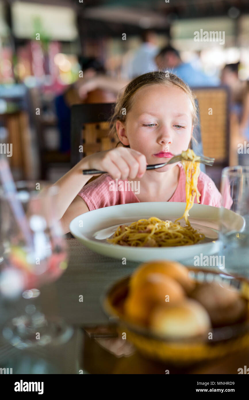 Adorable little girl eating delicious lunch in restaurant Stock Photo ...