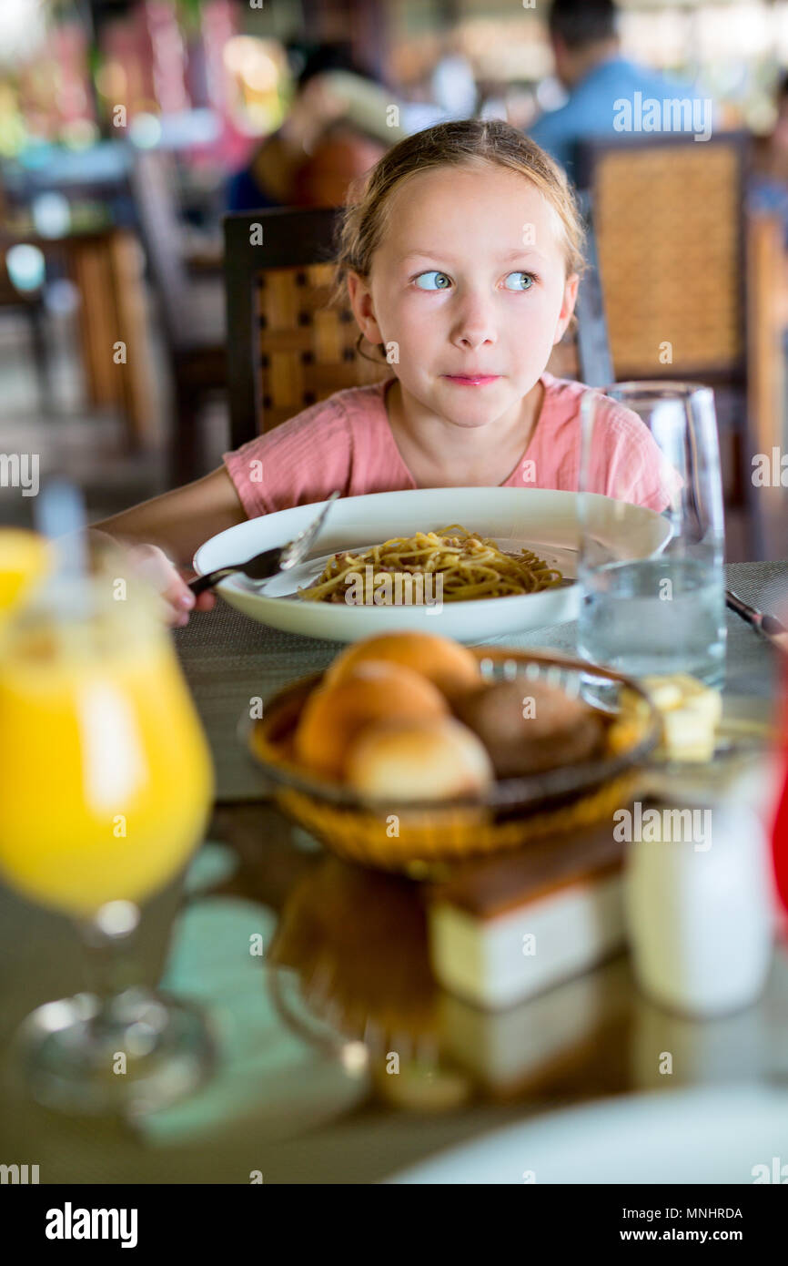 Adorable little girl eating delicious lunch in restaurant Stock Photo ...
