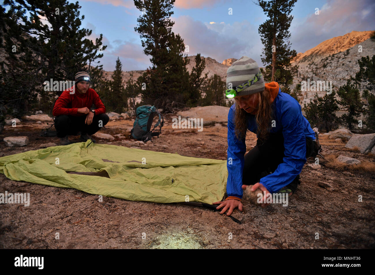 Backpackers setup their tent in evening light with headlamps at Grouse ...
