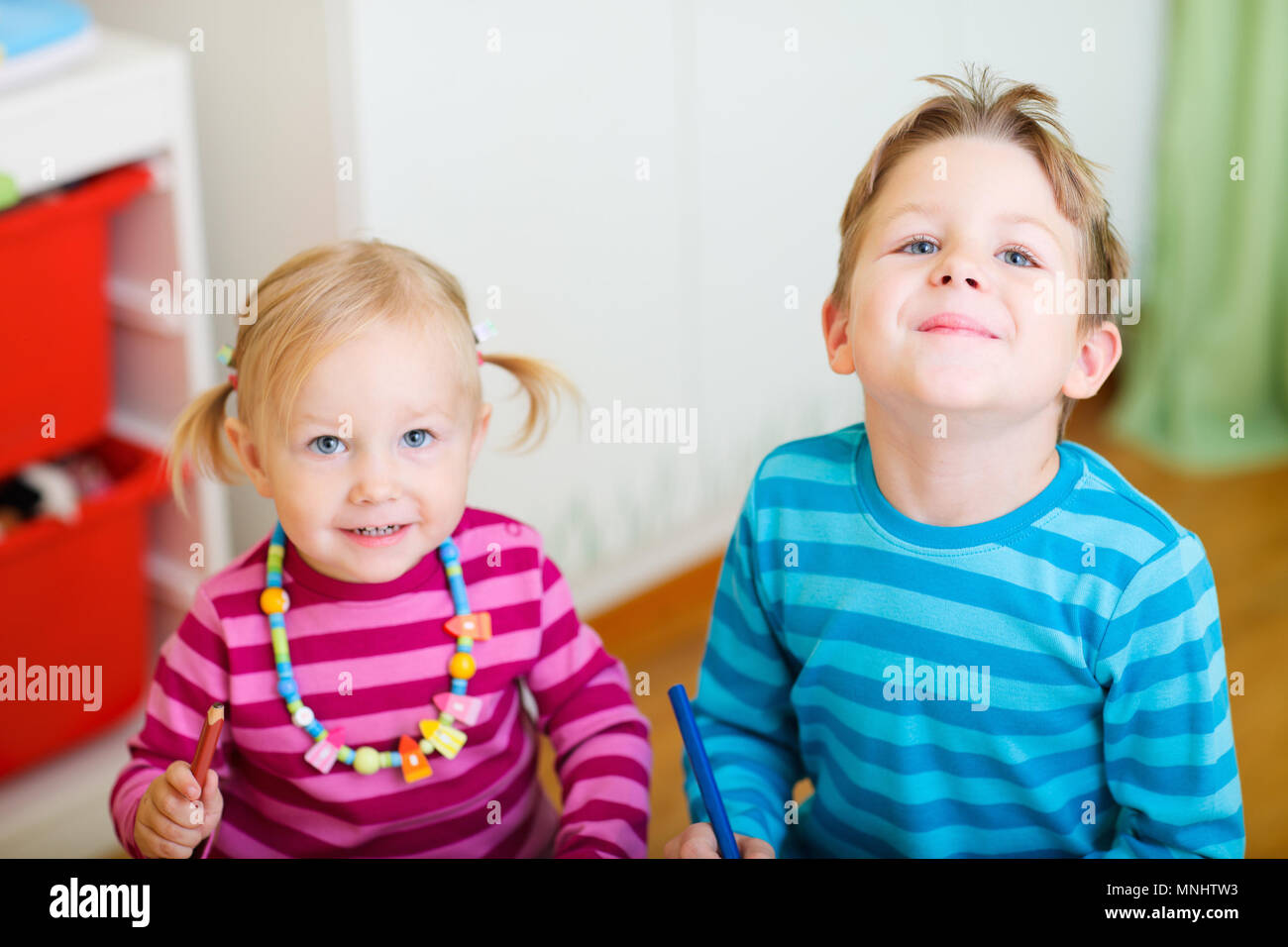 Portrait of two little kids drawing at home Stock Photo - Alamy