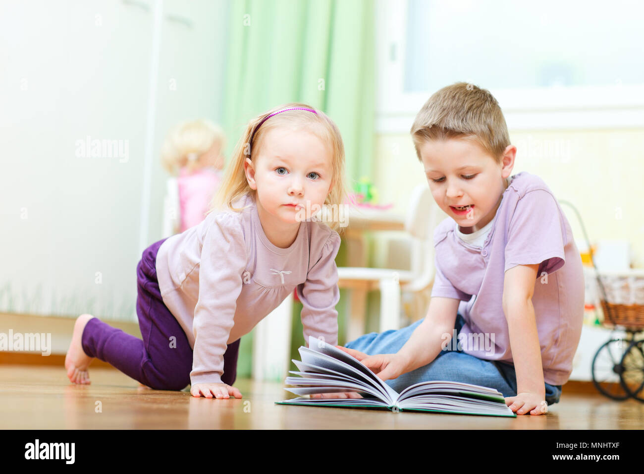 Two little kids playing together in kids room Stock Photo - Alamy
