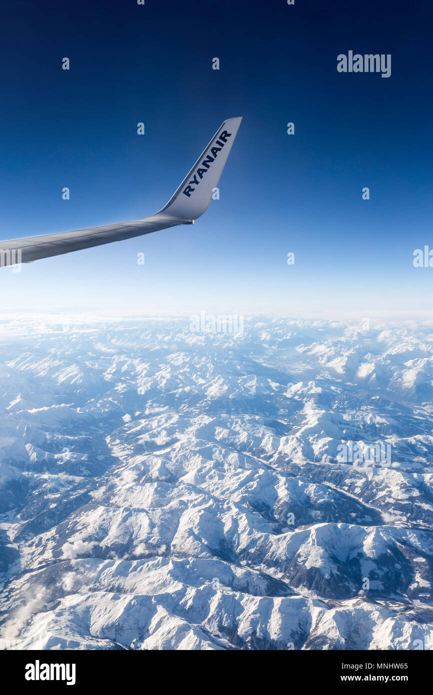 Alps, Europe - December, 2017: Wing of the Ryanair airplane Boeing 737 ...