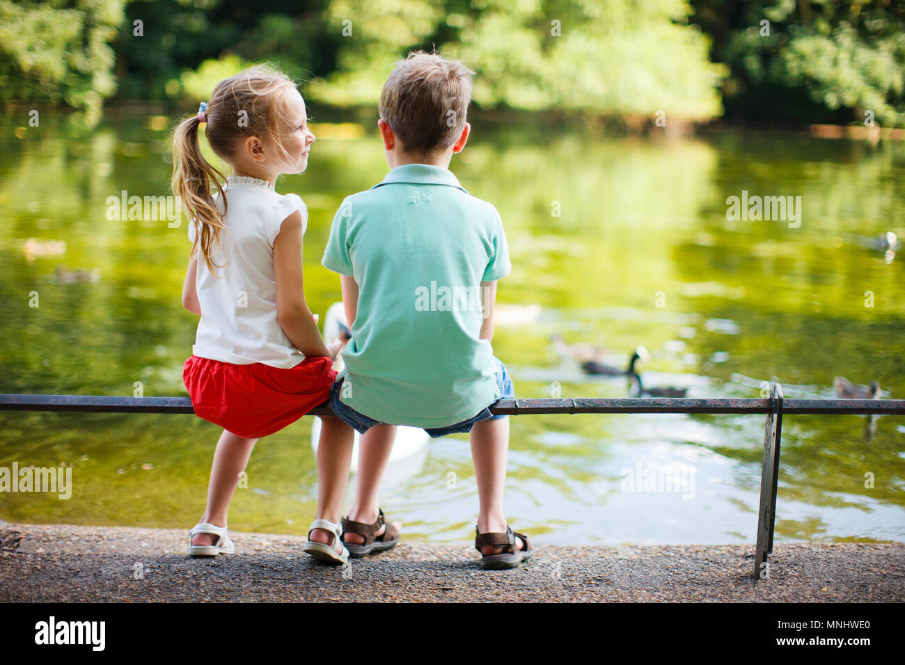 Back view of two kids outdoors at park Stock Photo - Alamy