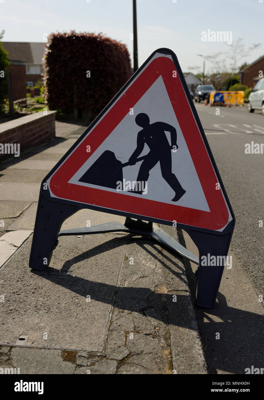 Triangular roadworks sign on damaged pavement in bury lancashire uk ...
