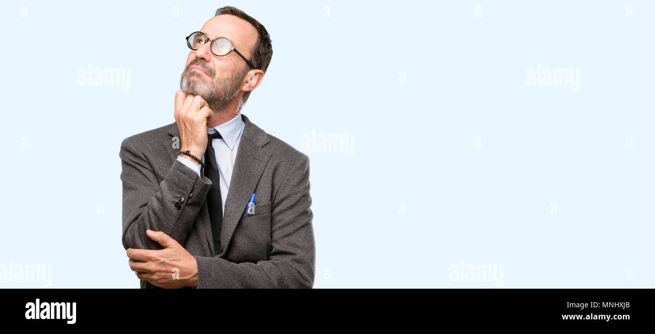 Teacher man using glasses thinking and looking up expressing doubt and ...