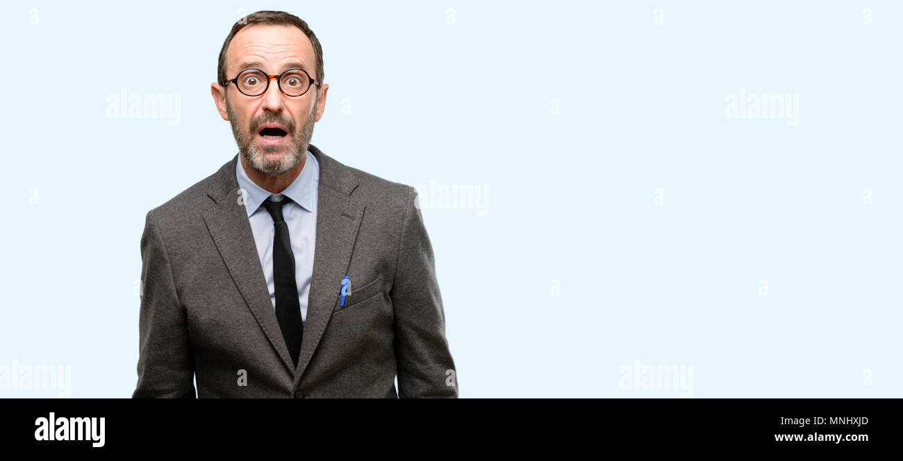 Teacher man using glasses scared in shock, expressing panic and fear ...