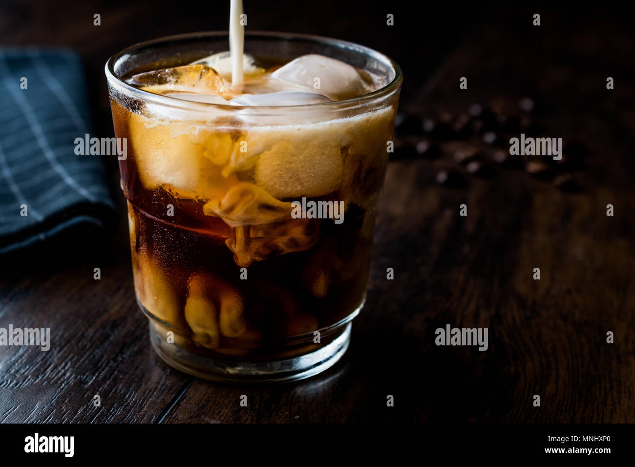 Pouring milk to iced coffee or cold brew. Organic Beverage Stock Photo ...