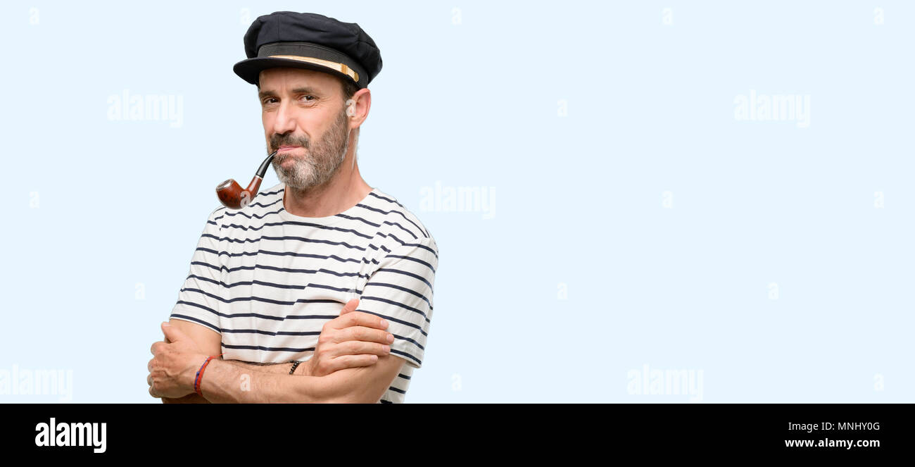 Sailor captain man smoking a tobacco pipe with crossed arms confident ...