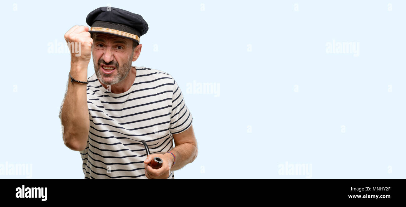 Sailor captain man smoking a tobacco pipe irritated and angry ...
