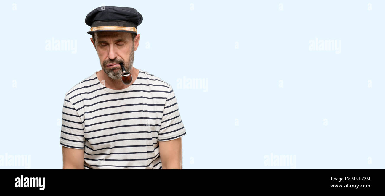 Sailor captain man smoking a tobacco pipe with sleepy expression, being ...
