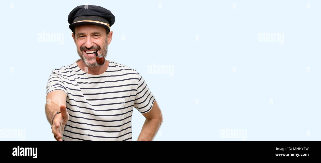 Sailor captain man smoking a tobacco pipe holds hands welcoming in ...