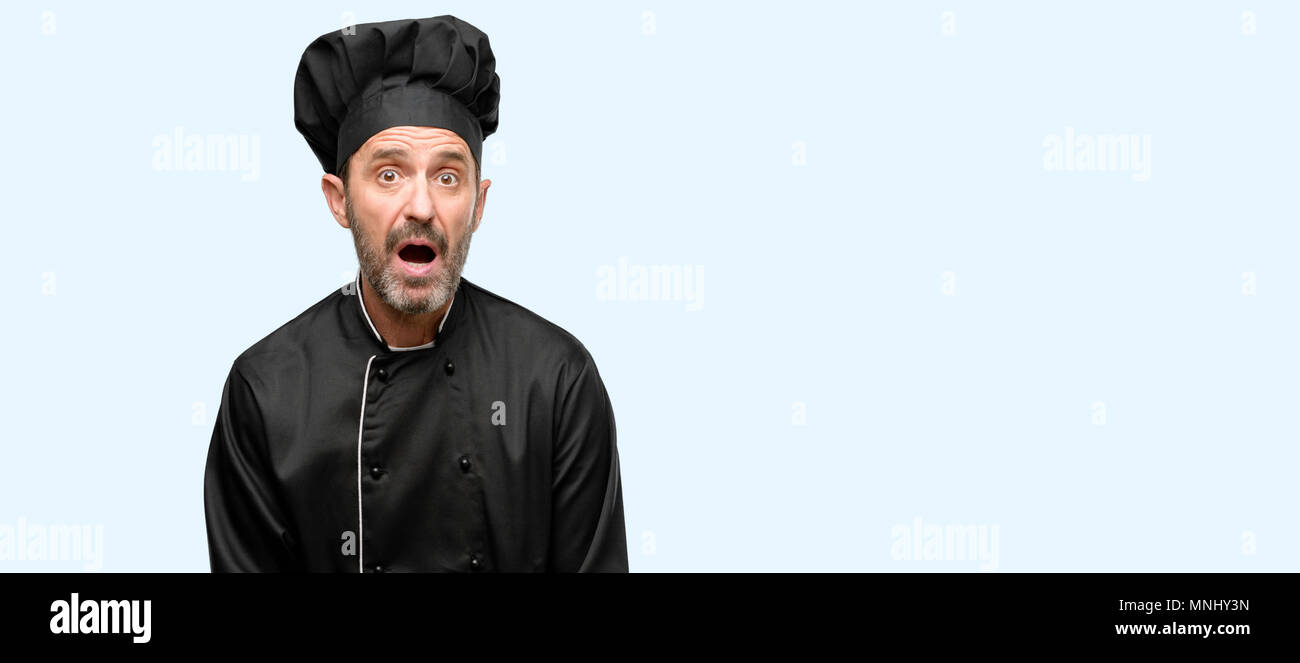 Senior cook man, wearing chef hat scared in shock, expressing panic and ...