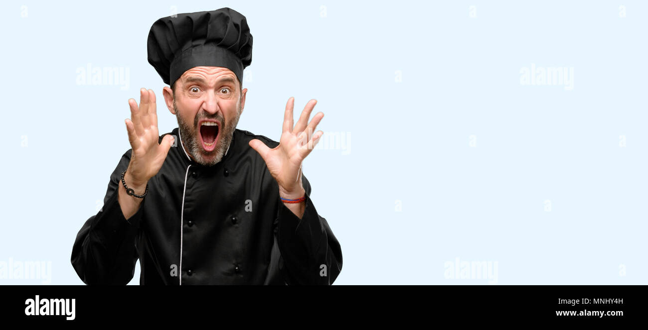 Senior cook man, wearing chef hat stressful keeping hands on head ...