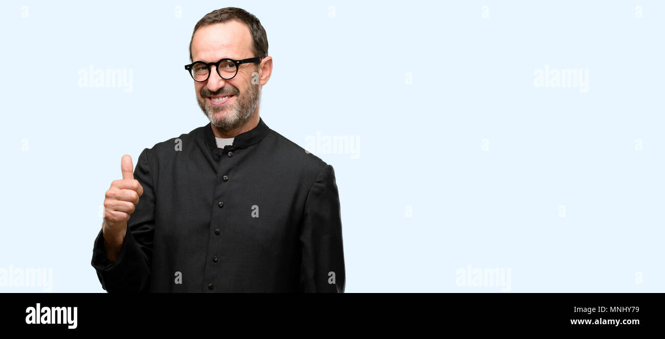 Priest religion man smiling broadly showing thumbs up gesture to camera ...
