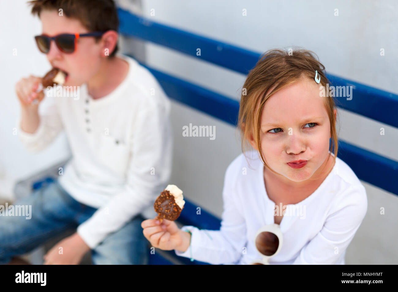 Two adorable kids eating ice cream outdoors on a hot summer day Stock ...