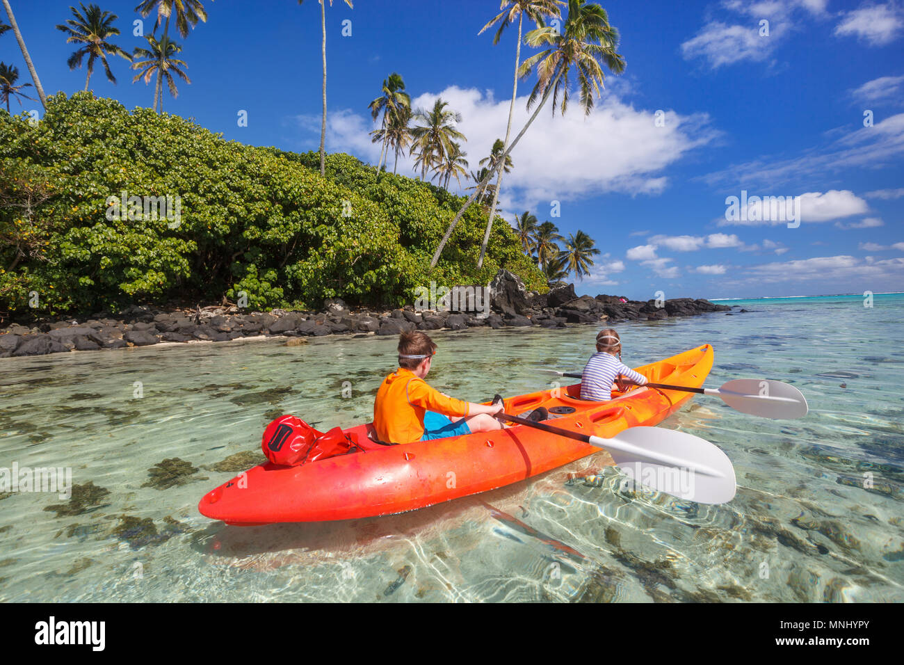 Kids enjoying paddling in colorful yellow kayak at tropical ocean water ...