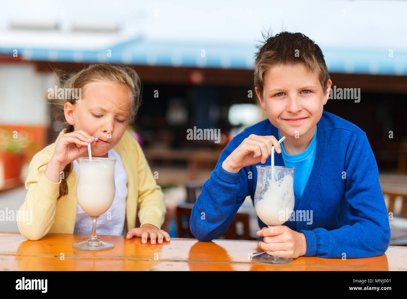Kids brother and sister drinking milkshakes in outdoor cafe Stock Photo ...