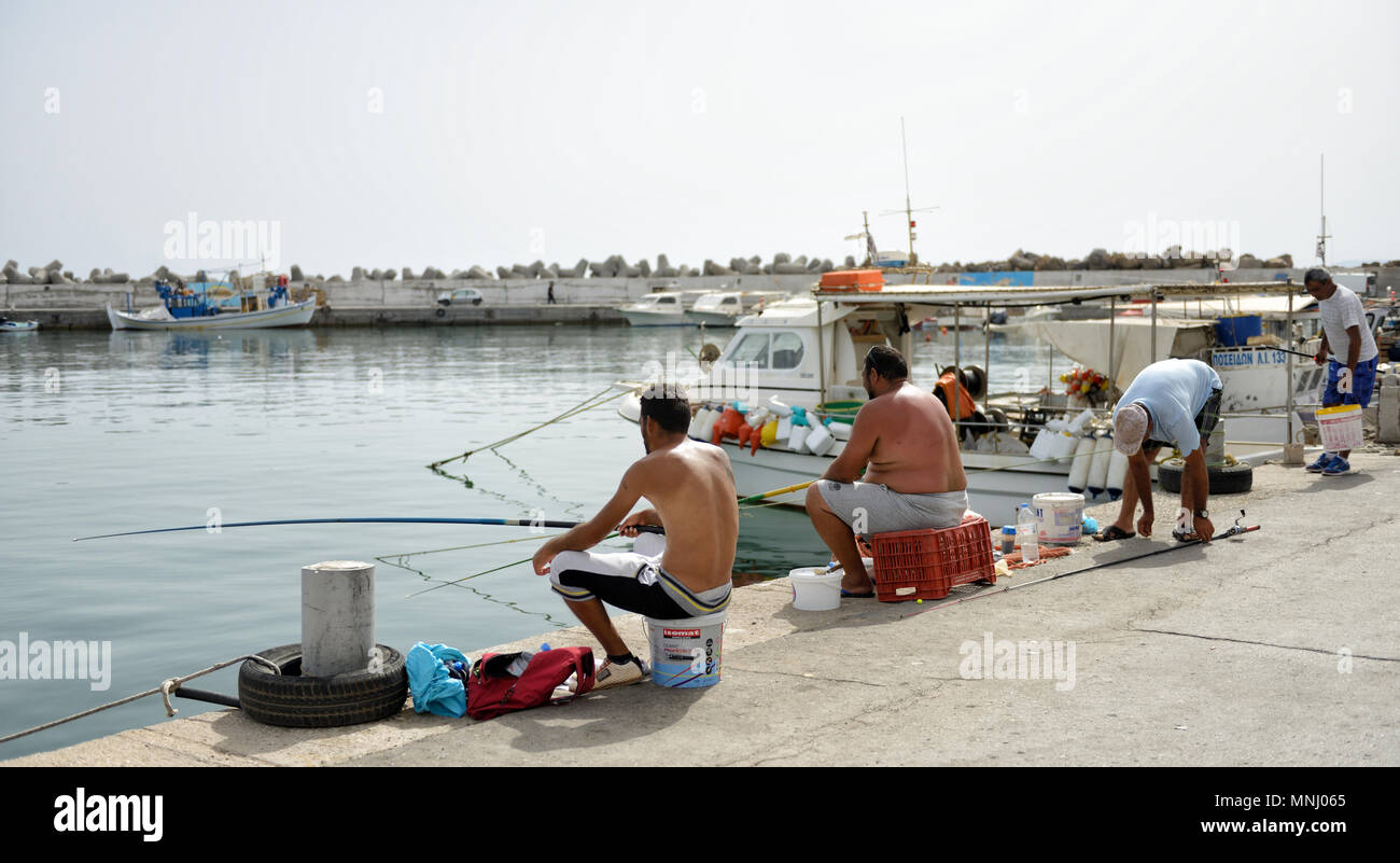 Little harbour in Crete, Greece.Fishermen catch fish with fishing rods ...