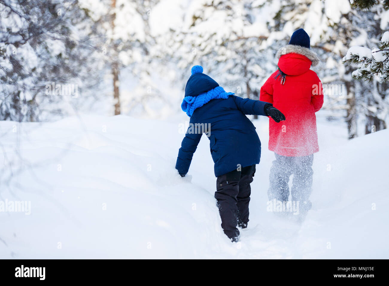Back view of little girl and cute boy outdoors on beautiful winter day ...
