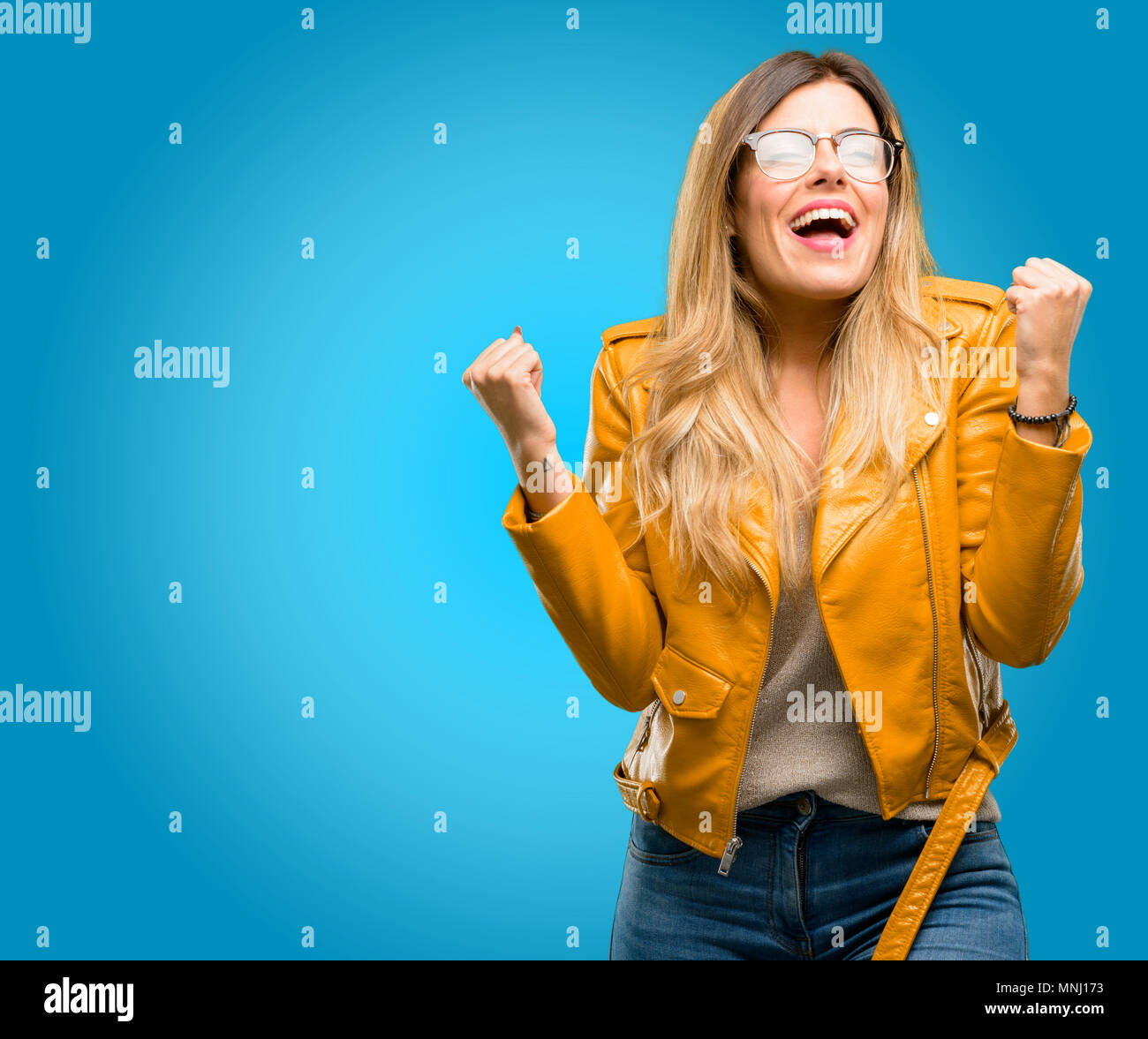 Beautiful young woman happy and excited expressing winning gesture ...